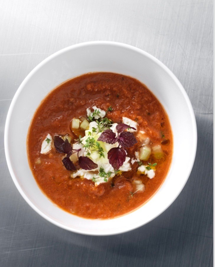 Kyld tomatsoppa serveras med chèvre, olivolja och basilika - DinVinguide